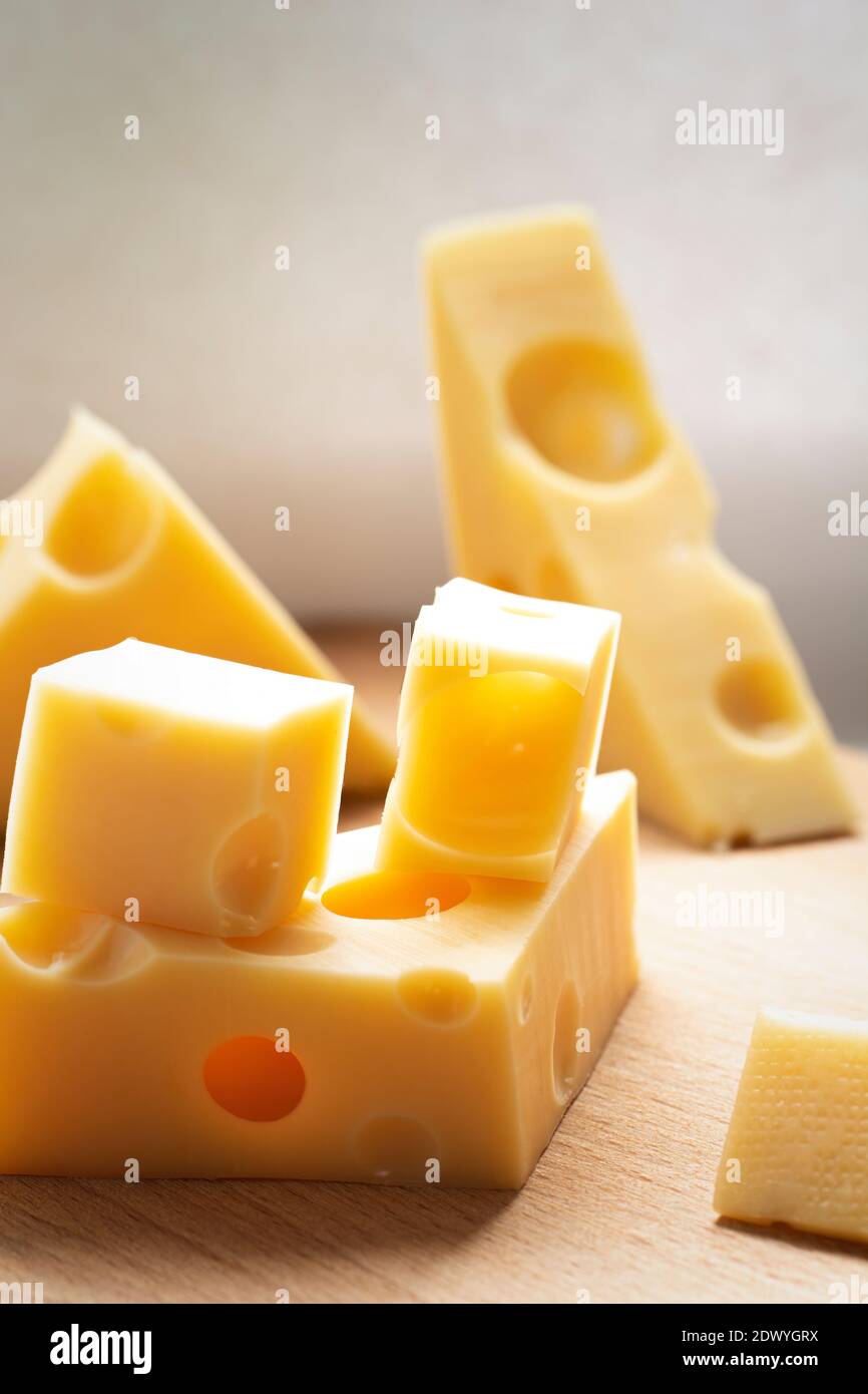 Pieces of fresh yellow cheese, chunk on wooden table. Dairy product ...