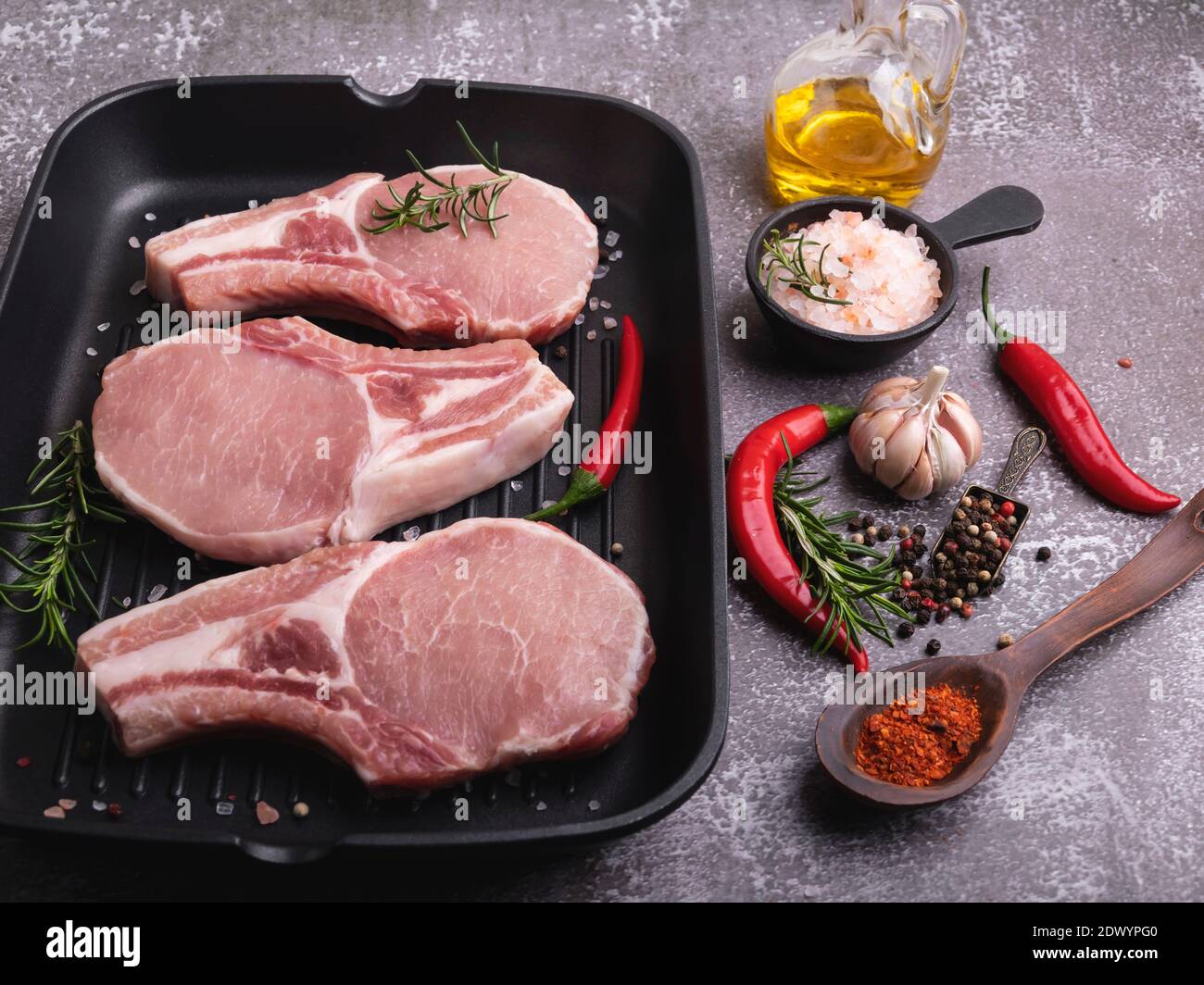 fresh raw pieces meat pork, beef, chop on a bone, on grill pan, spices ...