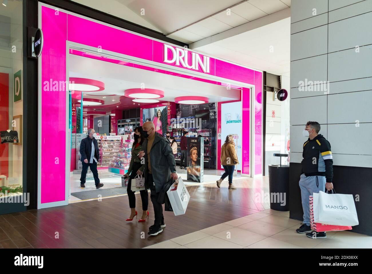 People wearing face masks walk past the Druni store at the Bonaire ...