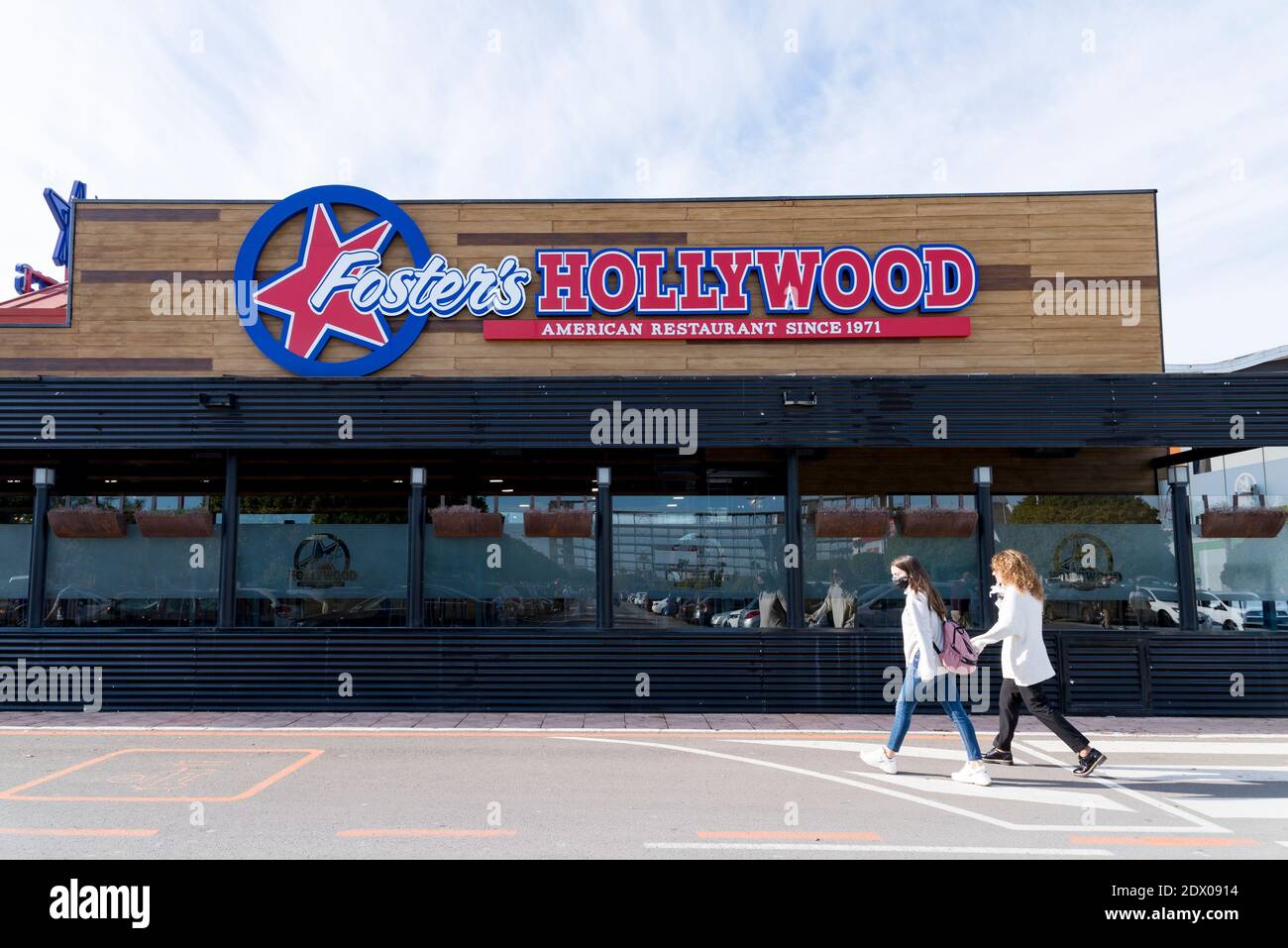 Two women wearing face masks walk in front of the fast food restaurant ...