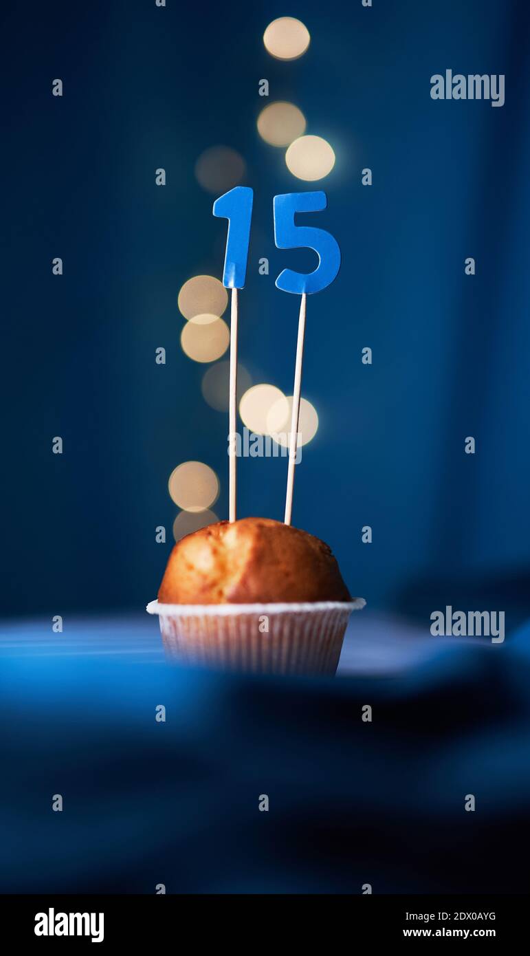 Birthday cake or muffin with fifteen (15) number and lights on the blue ...