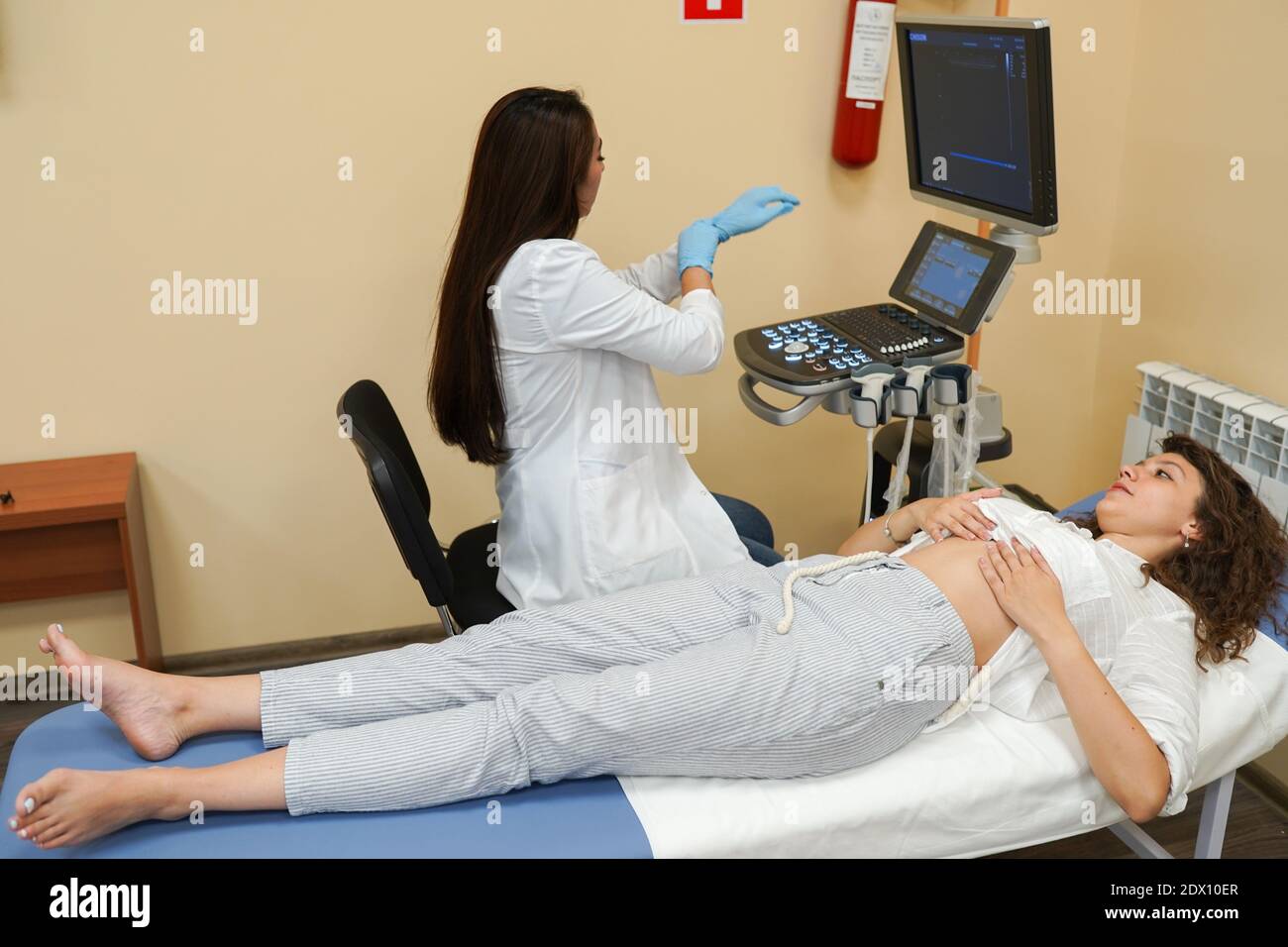 Doctor and young woman patient. Ultrasound equipment. Diagnostics ...