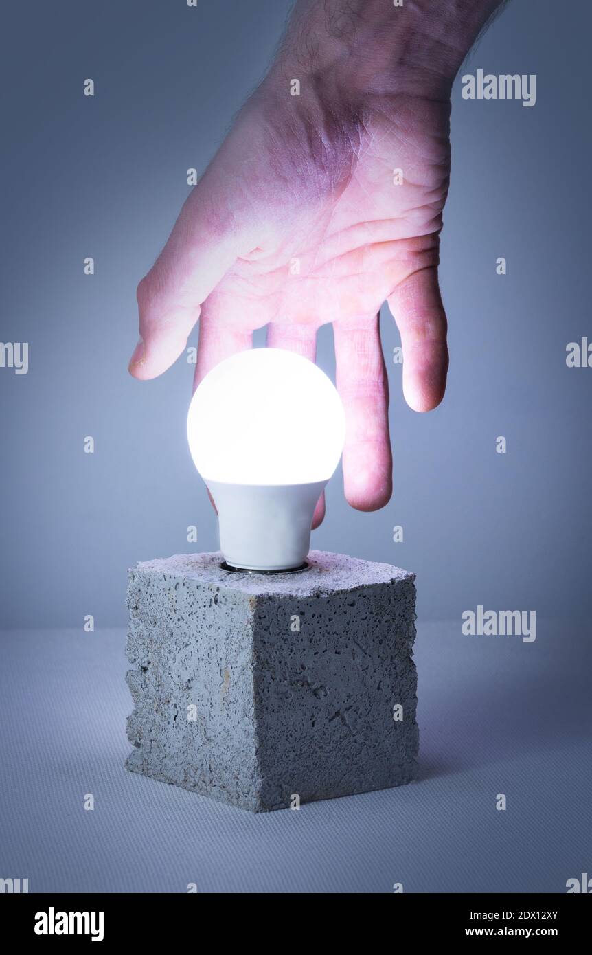 From above, a hand reaches for a lamp emitting light Stock Photo - Alamy