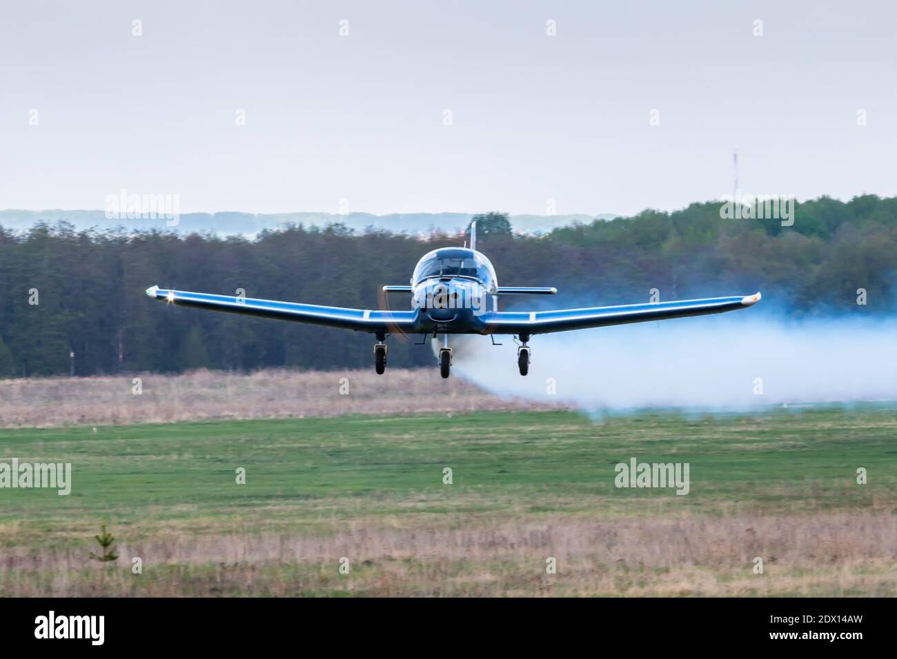 Low pass of a small sports airplane with smoke Stock Photo - Alamy