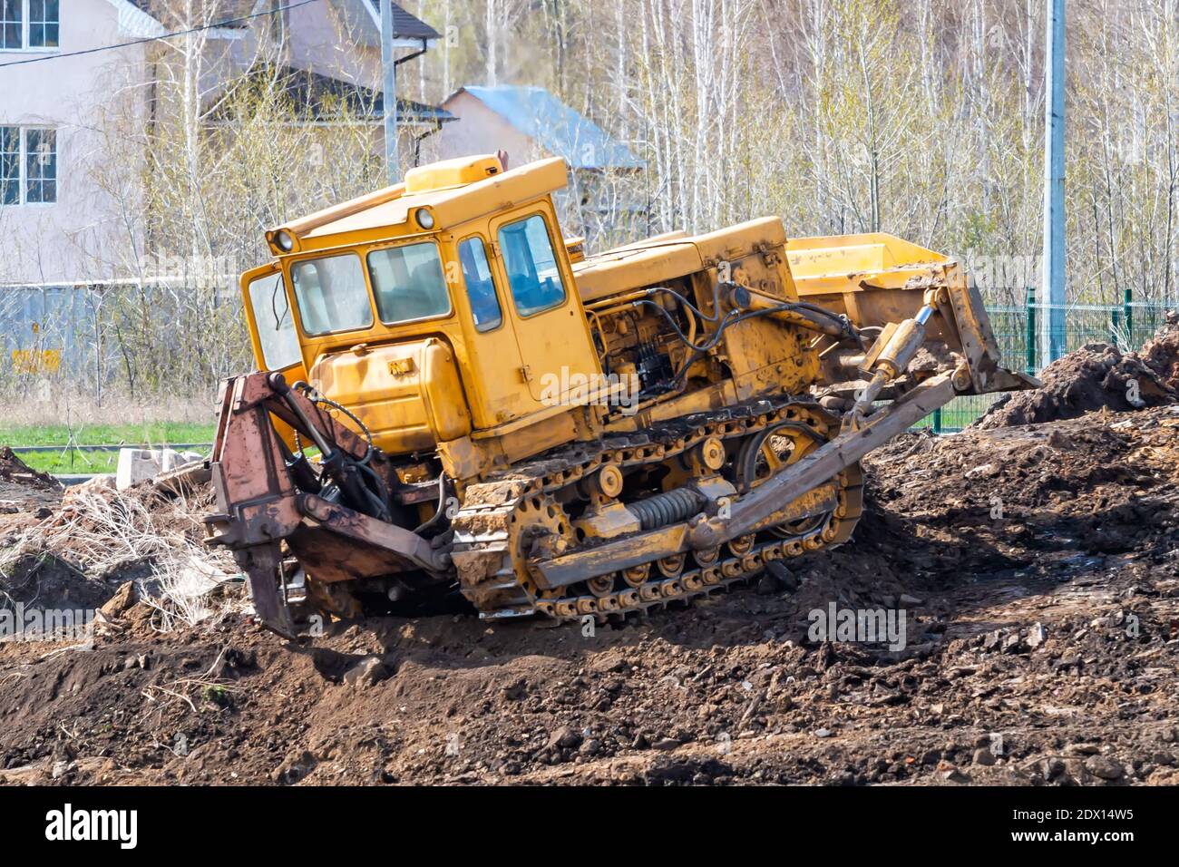 Yellow bulldozer leveling the ground at a construction site Stock Photo ...
