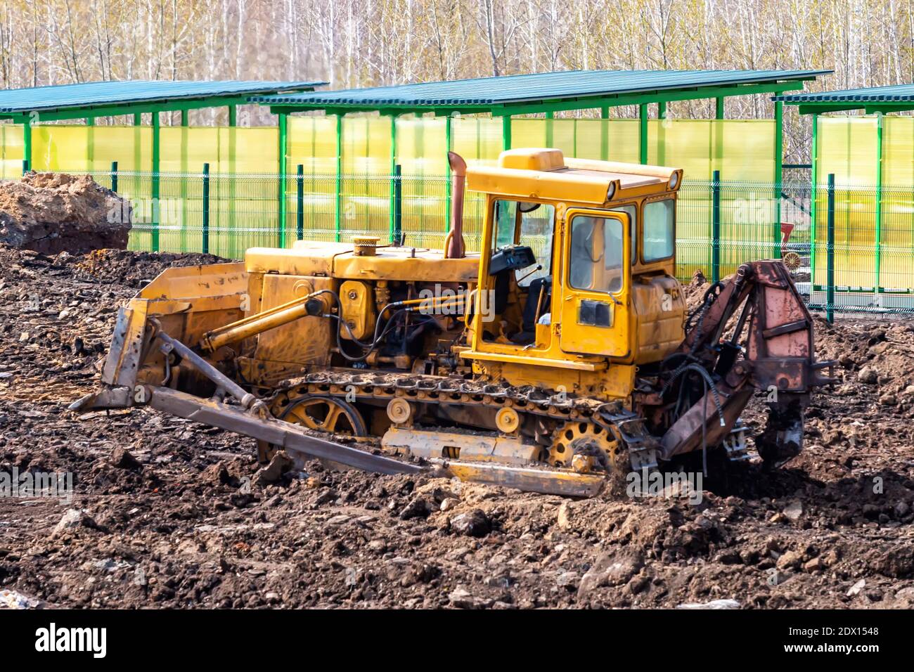 Yellow bulldozer leveling the ground at a construction site Stock Photo ...