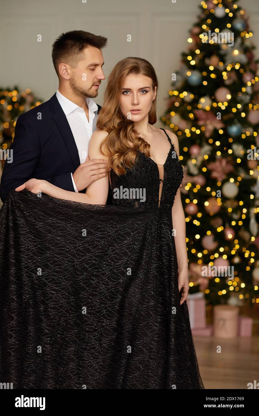 Beautiful couple celebrating Christmas together. woman in black dress ...