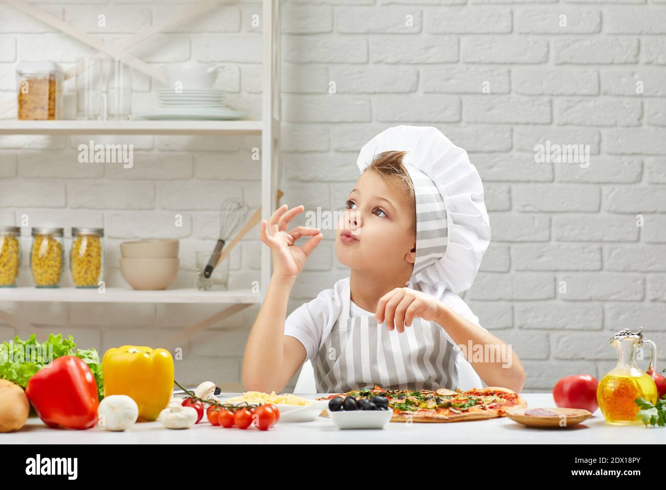 child making tasty delicious gesture by kissing fingers. little boy in ...