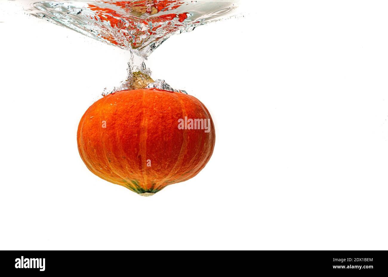 Orange pumpkin splashing into water isolated against white background ...