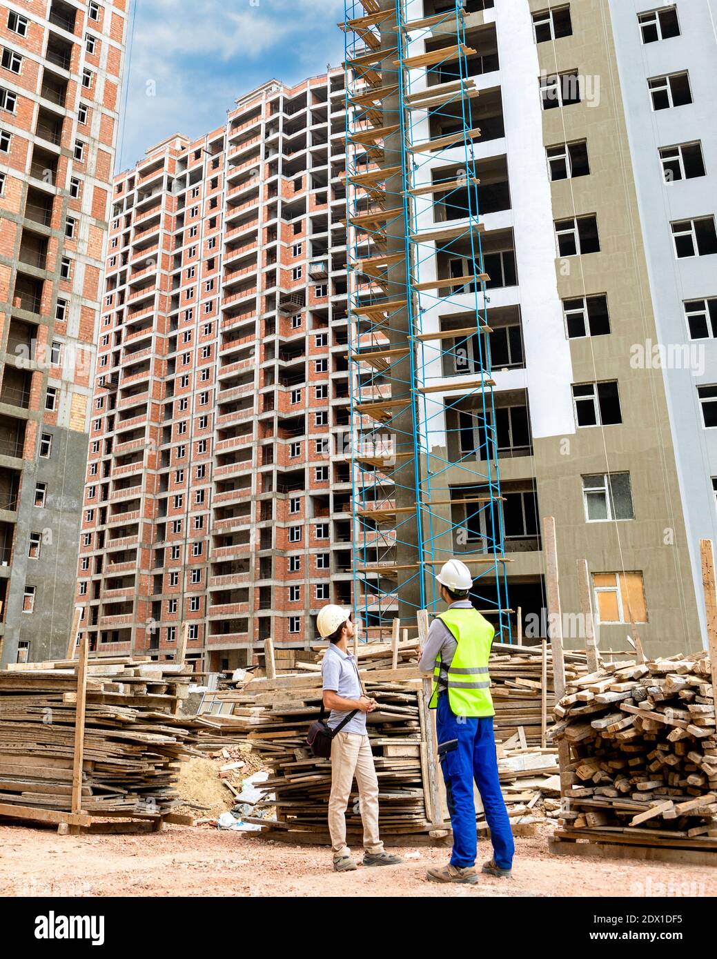 Construction workers standing in front of the high building Stock Photo ...