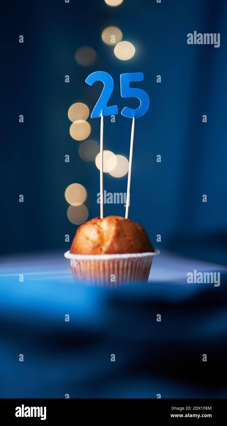 Birthday cupcake or muffin with number twenty five (25) and lights on ...