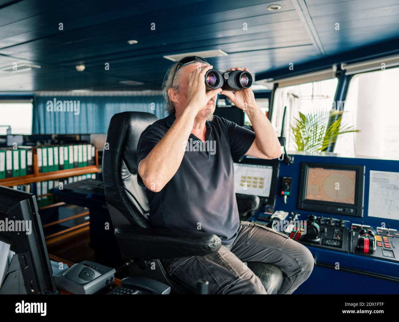 Captain of vessel or ship. He is looking through binoculars Stock Photo ...