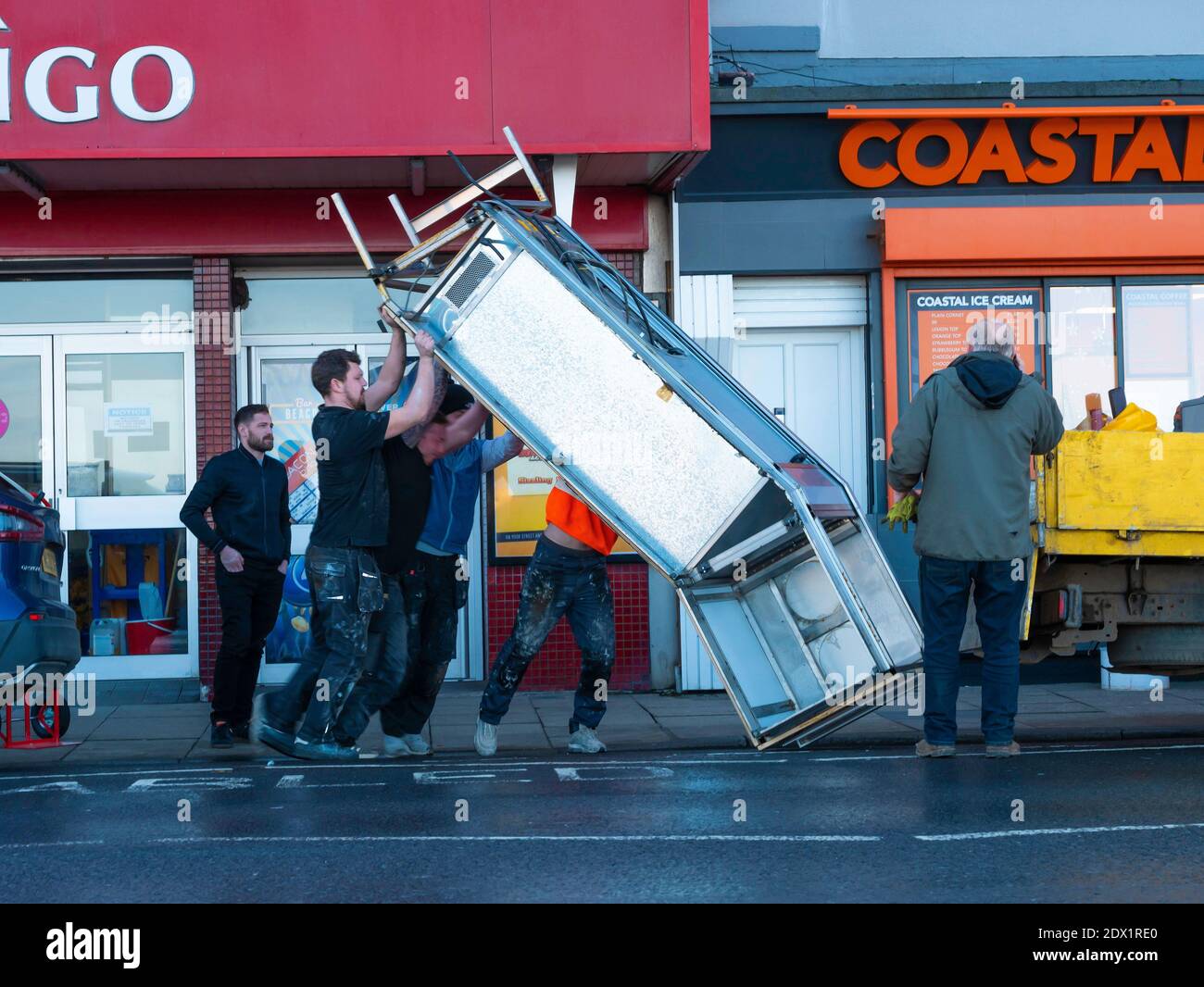 Workmen manhandling a machine from an Amusement Arcade and load it on ...