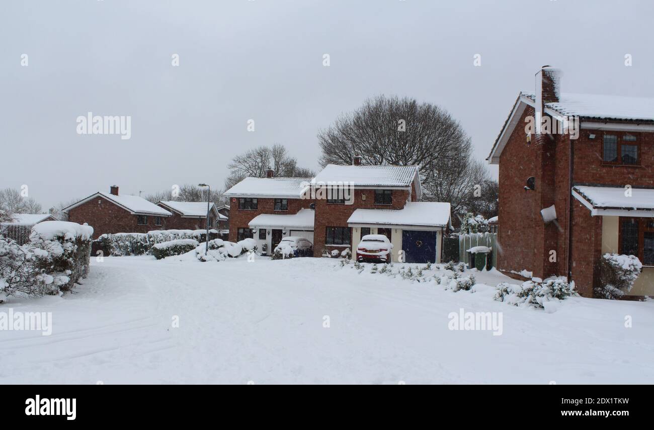 A snowy, winter scene of a housing street covered in deep snow in the ...