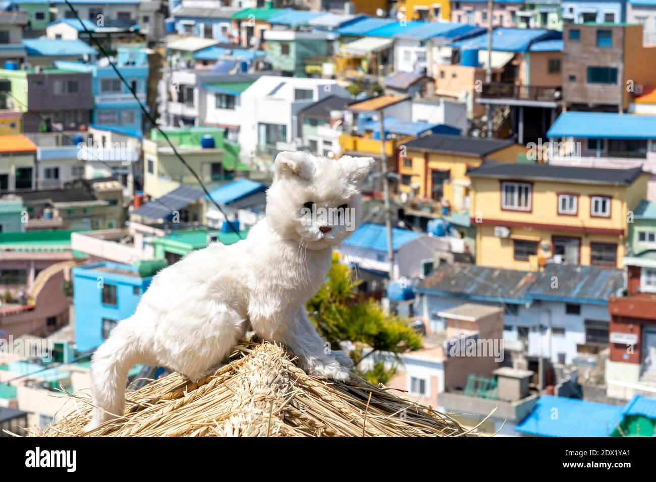 A cat statue on straw roof with Gamcheon Culture Village in background ...