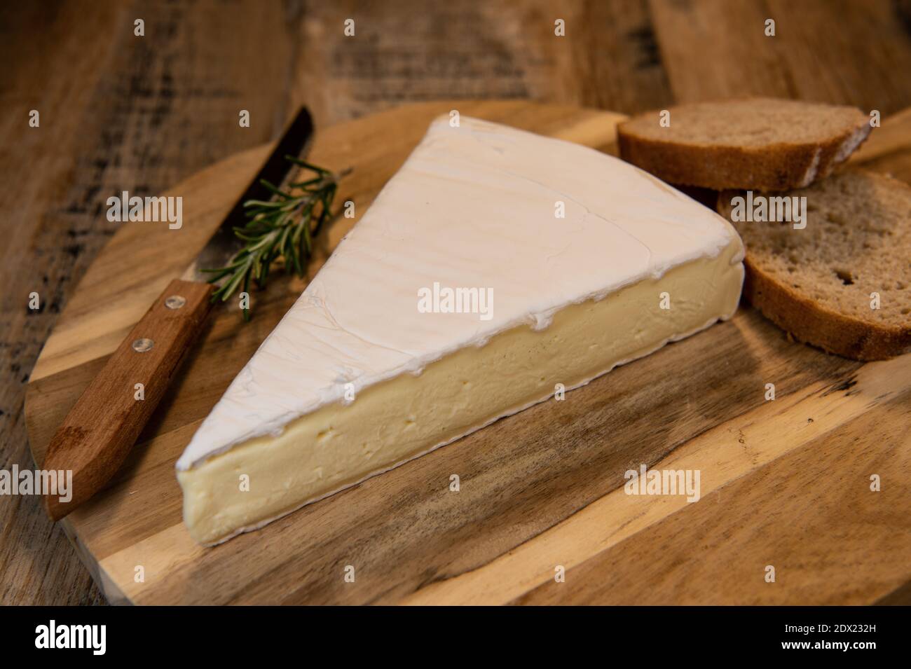 Brie cheese triangle with bread and parsley Stock Photo - Alamy