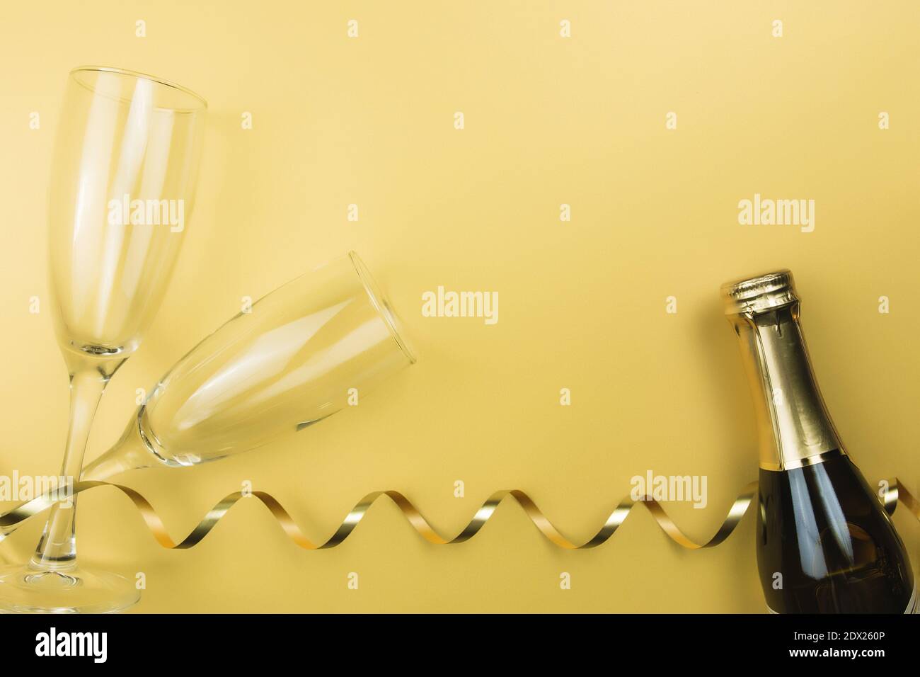 Glasses, sparkling wine bottle, ribbon, gold background Stock Photo - Alamy