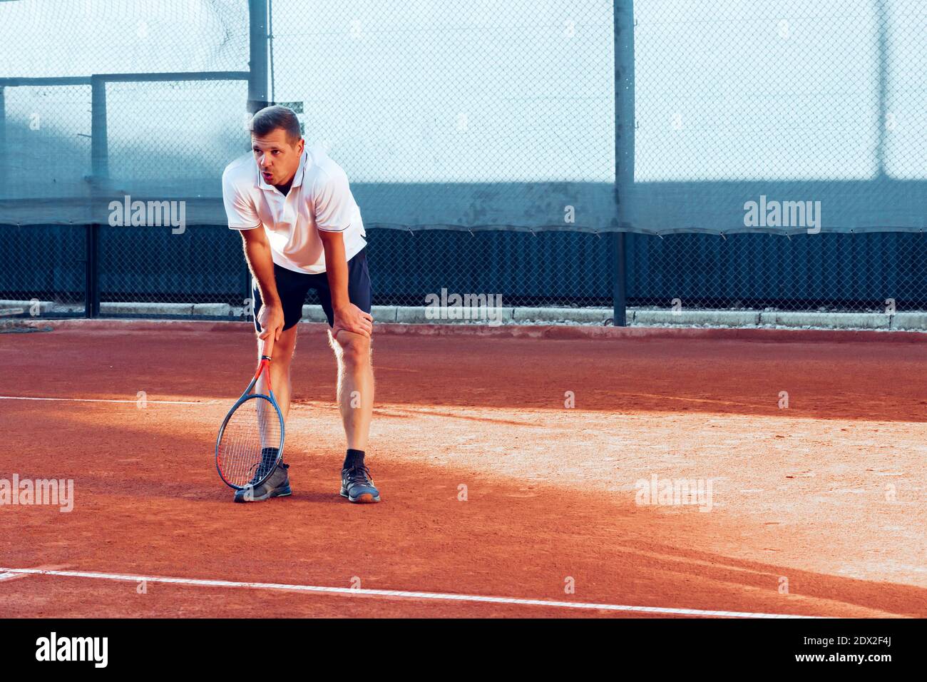 Man tennis player gets tired during his training Stock Photo - Alamy