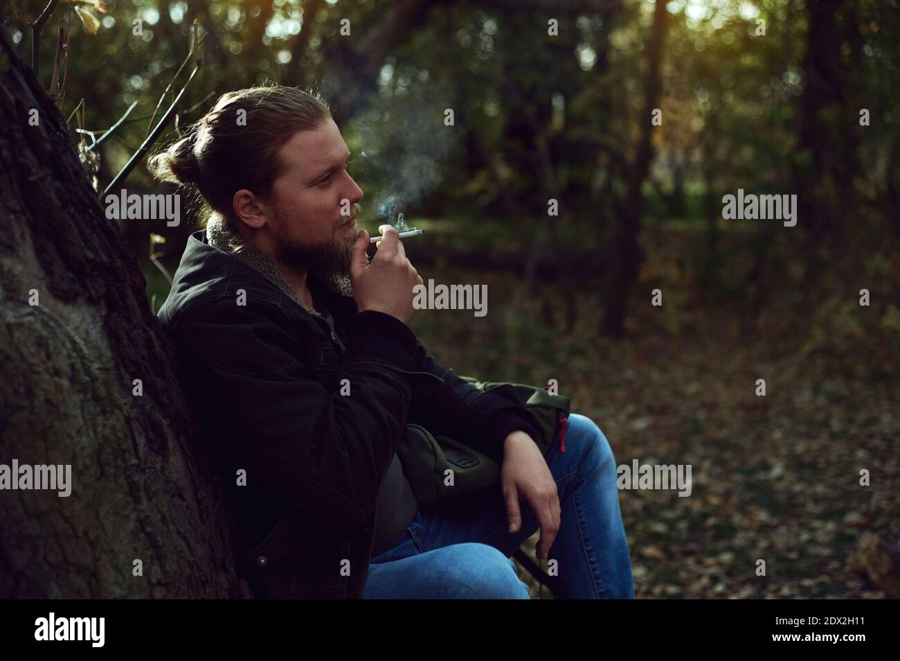 Side photo of a smoking man in the autumn forest Stock Photo - Alamy