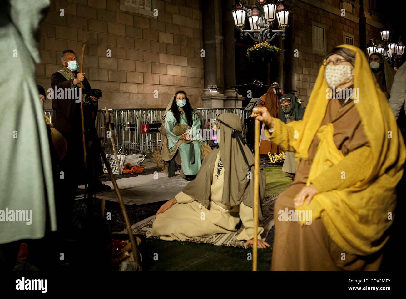 People dressed in biblical costumes and wearing face masks perform a ...