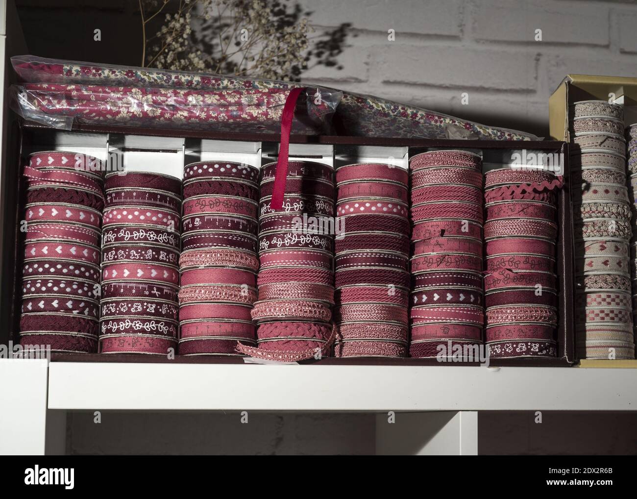 Red ribbons on spools stacked on a shelf Stock Photo - Alamy