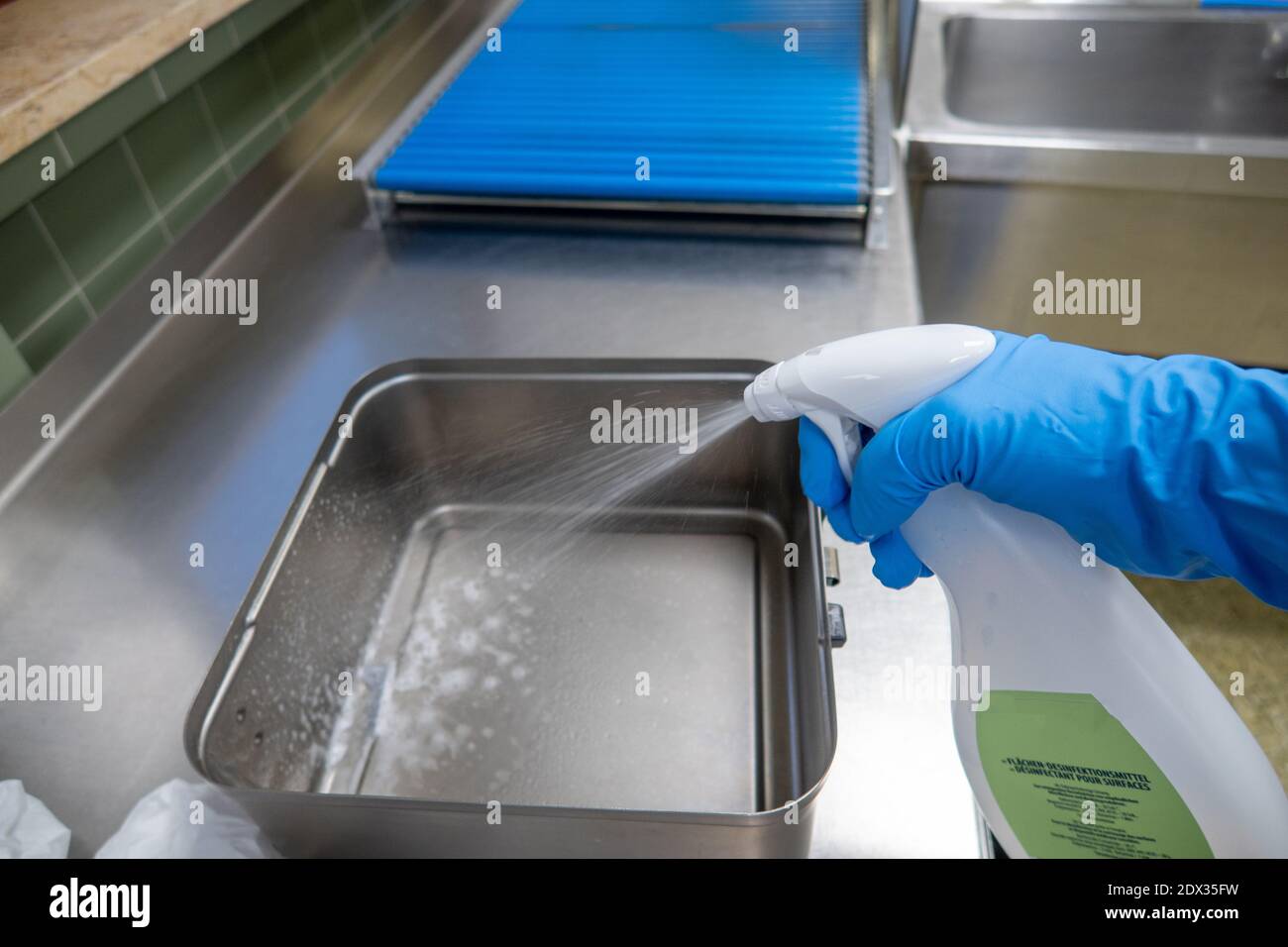a metal container is disinfected with a disinfectant from a spray ...