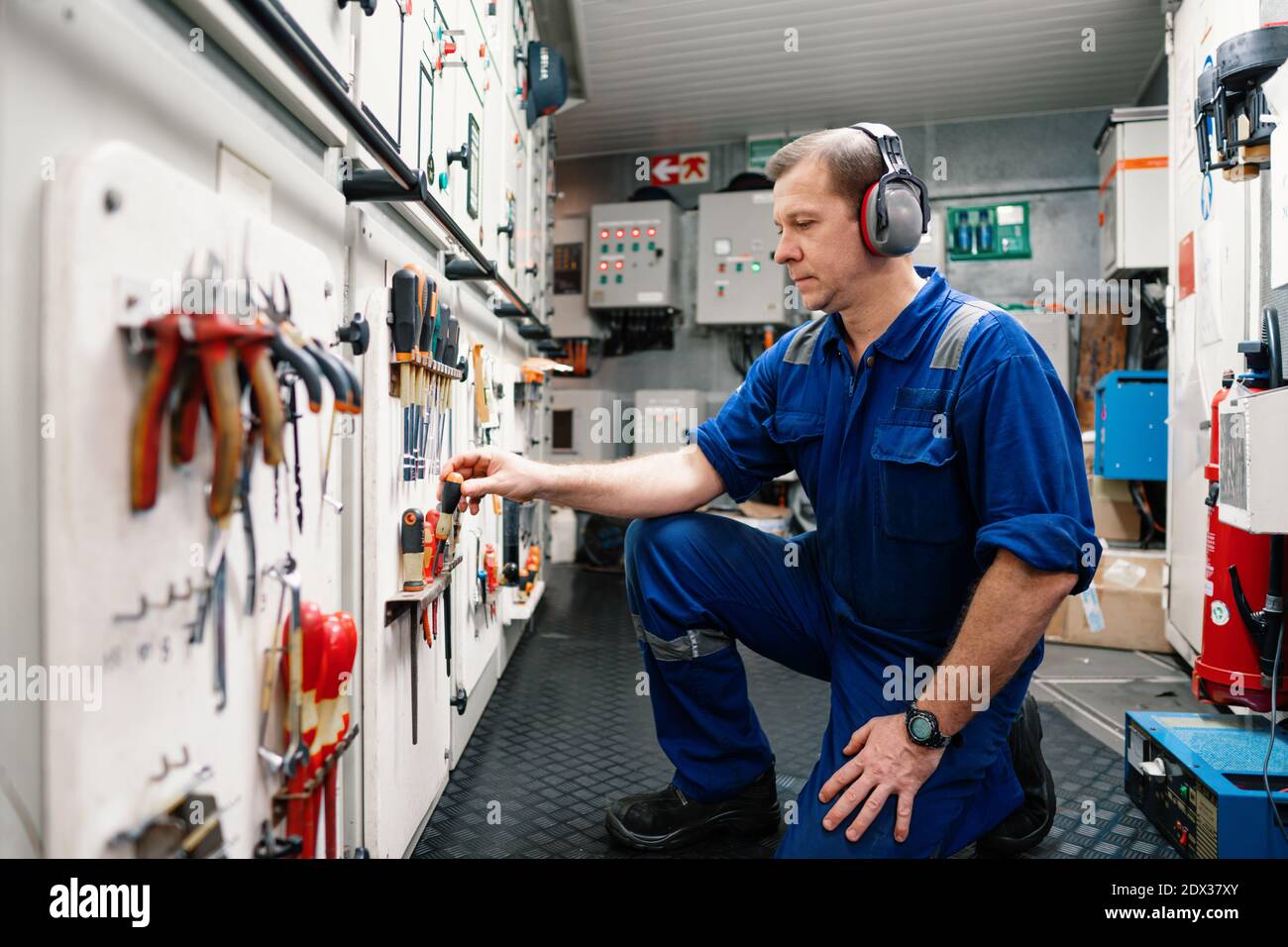 Marine engineer officer in engine control room ECR. He works in ...