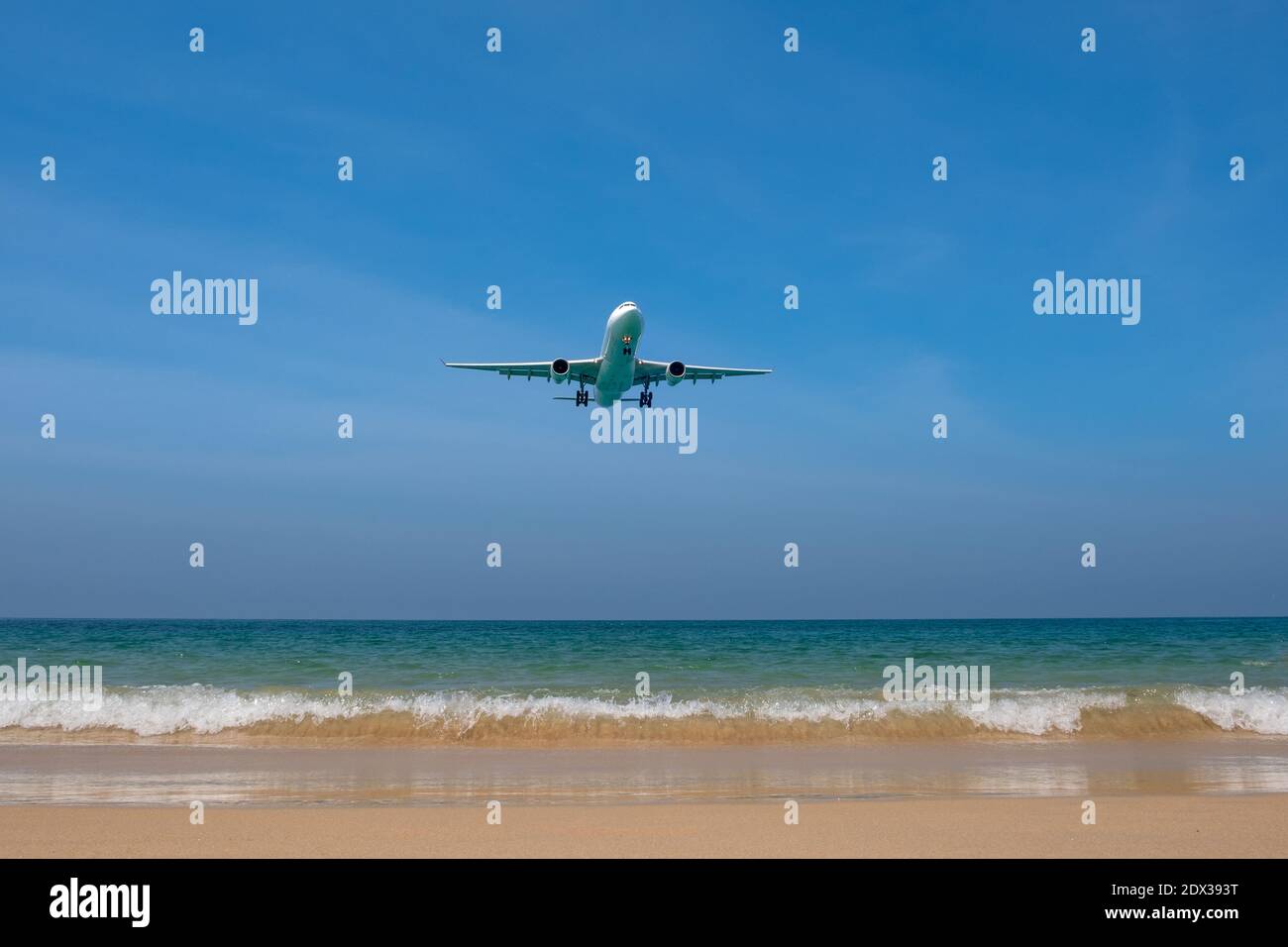 The plane lands on landing over Mai Khao Beach in Thailand. Under the ...