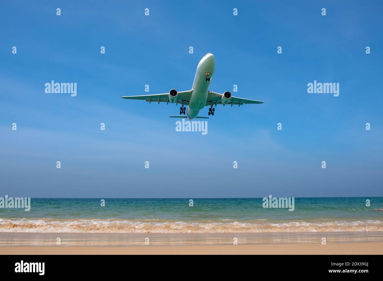 Passenger Airplane flies over a beautiful beach with fine sand and blue ...