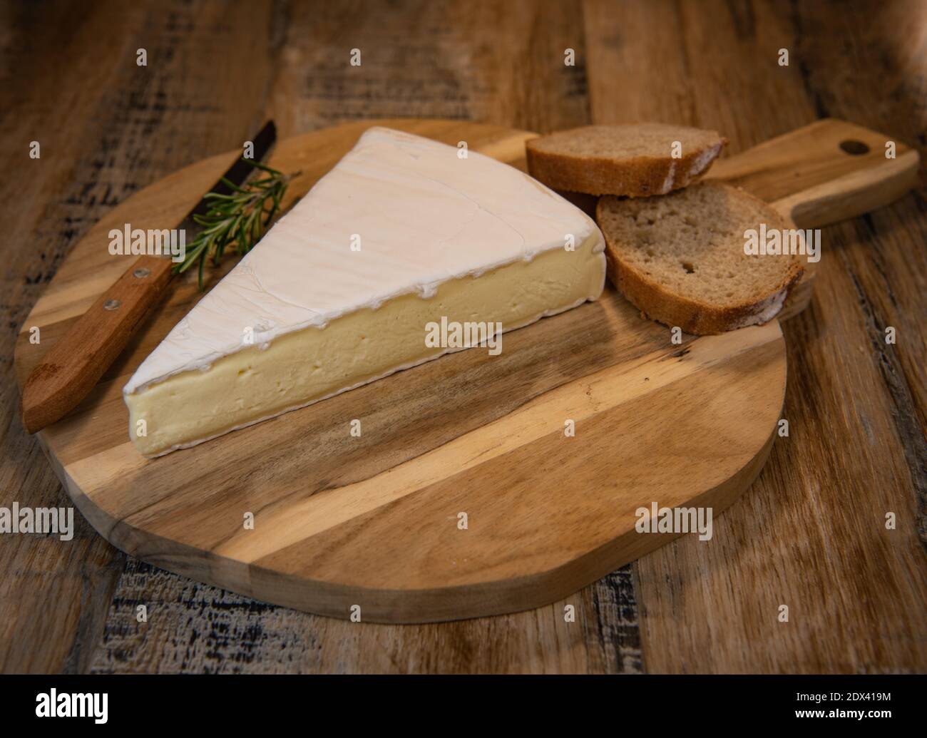 Brie cheese triangle with bread and parsley Stock Photo - Alamy