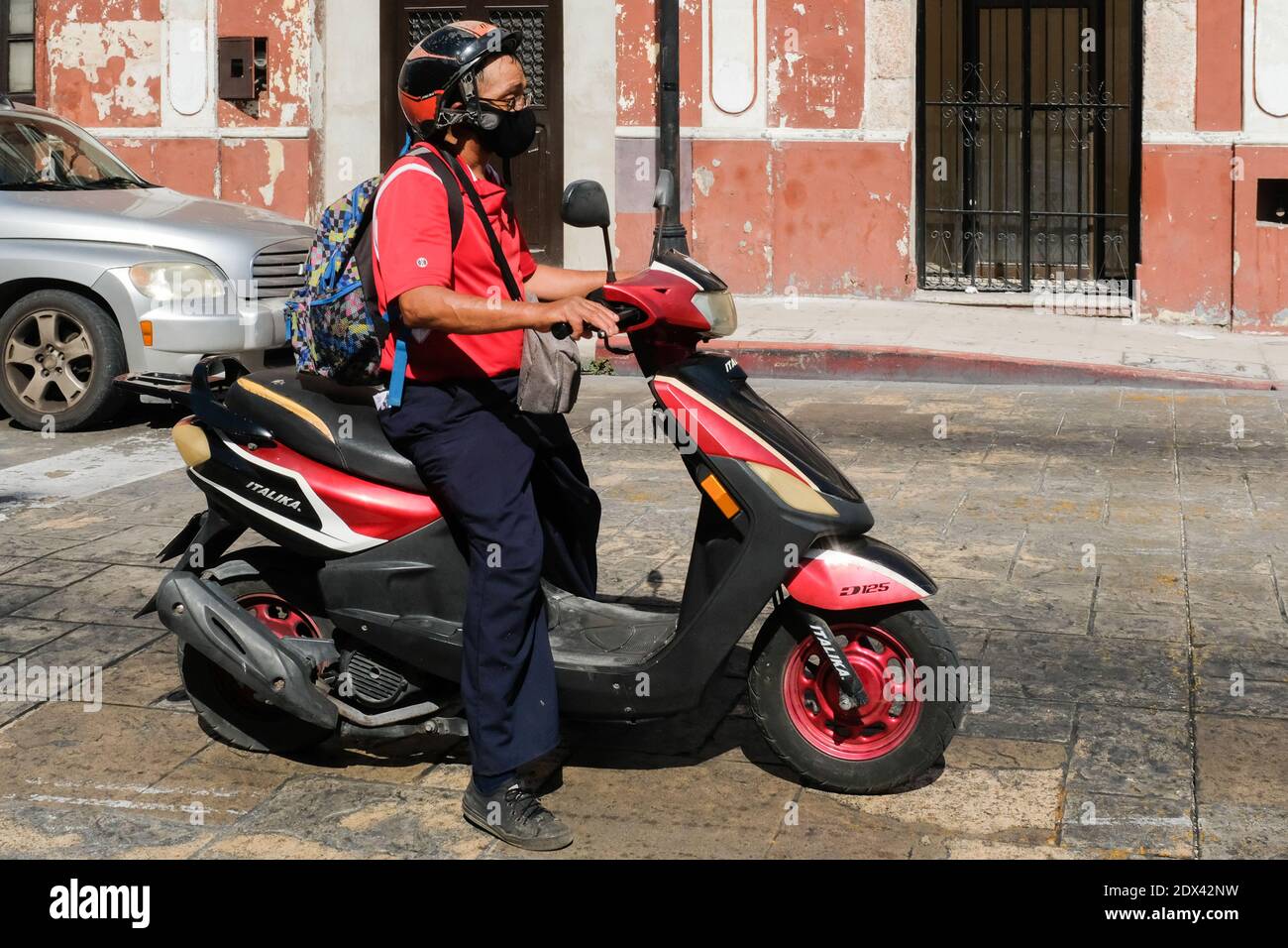 Man riding vespa wearing a face mask, Merida Mexico Stock Photo - Alamy