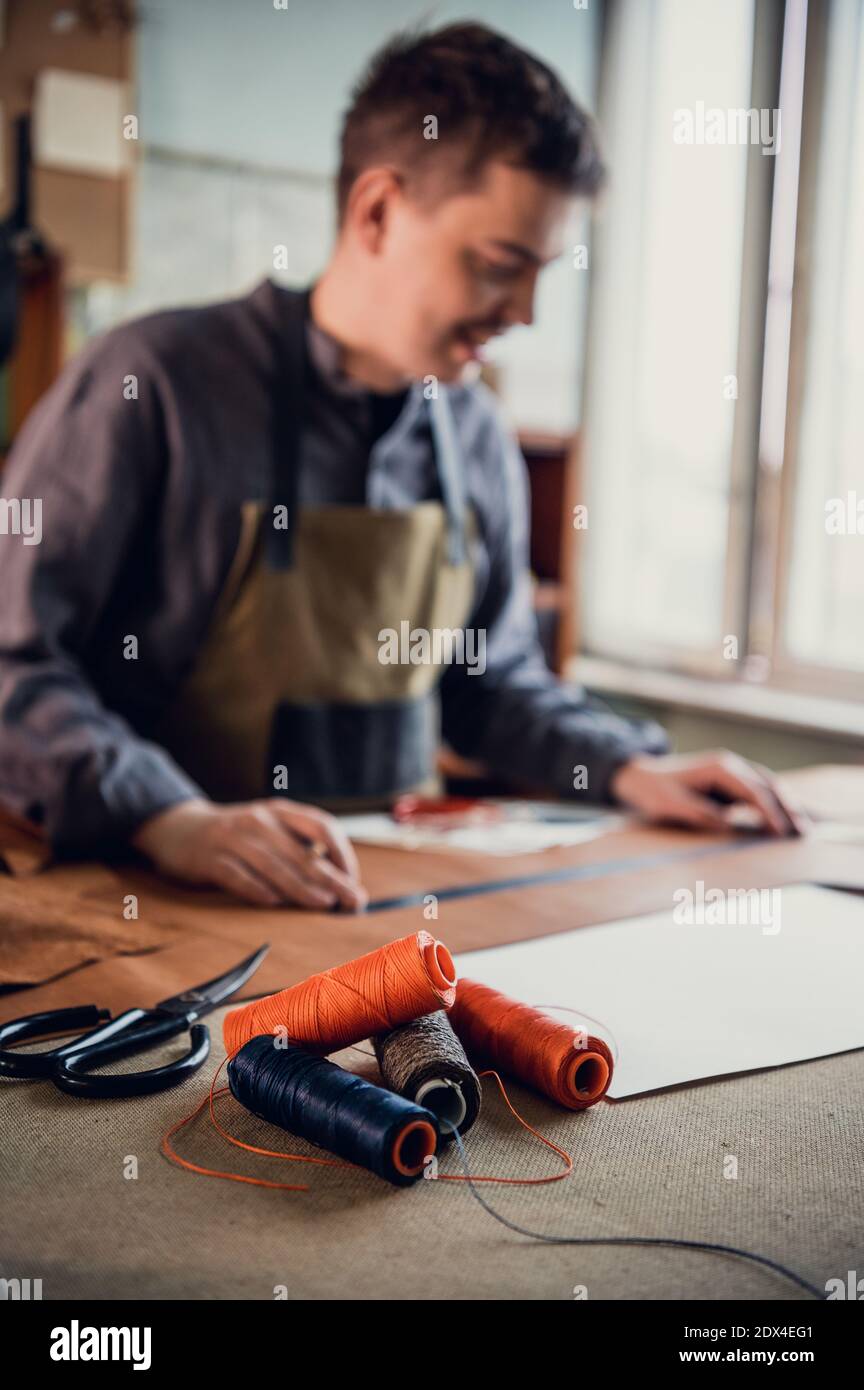 Old school workshop of an exclusive shoemaker. Spools of thread on the ...