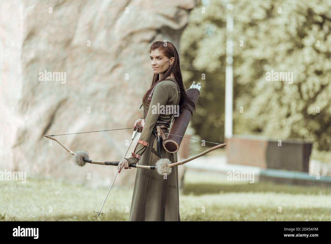 Archery woman with bow shooting on the forest Stock Photo - Alamy