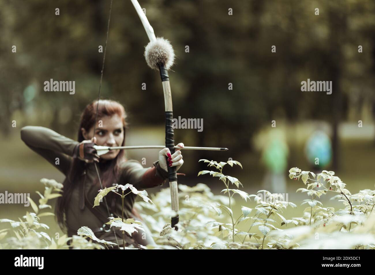 Young woman holding bow arrow hi-res stock photography and images - Alamy