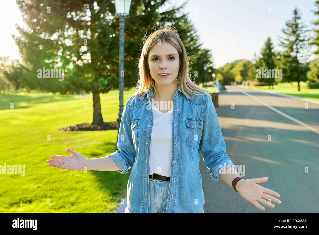 Gesturing young beautiful woman talking at camera, teenager student ...