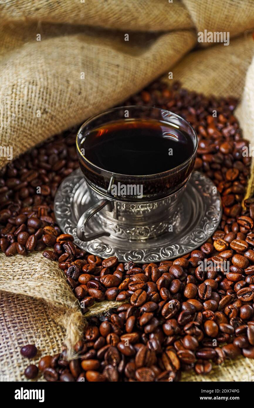 Silver coffee cup with coffee beans Stock Photo - Alamy