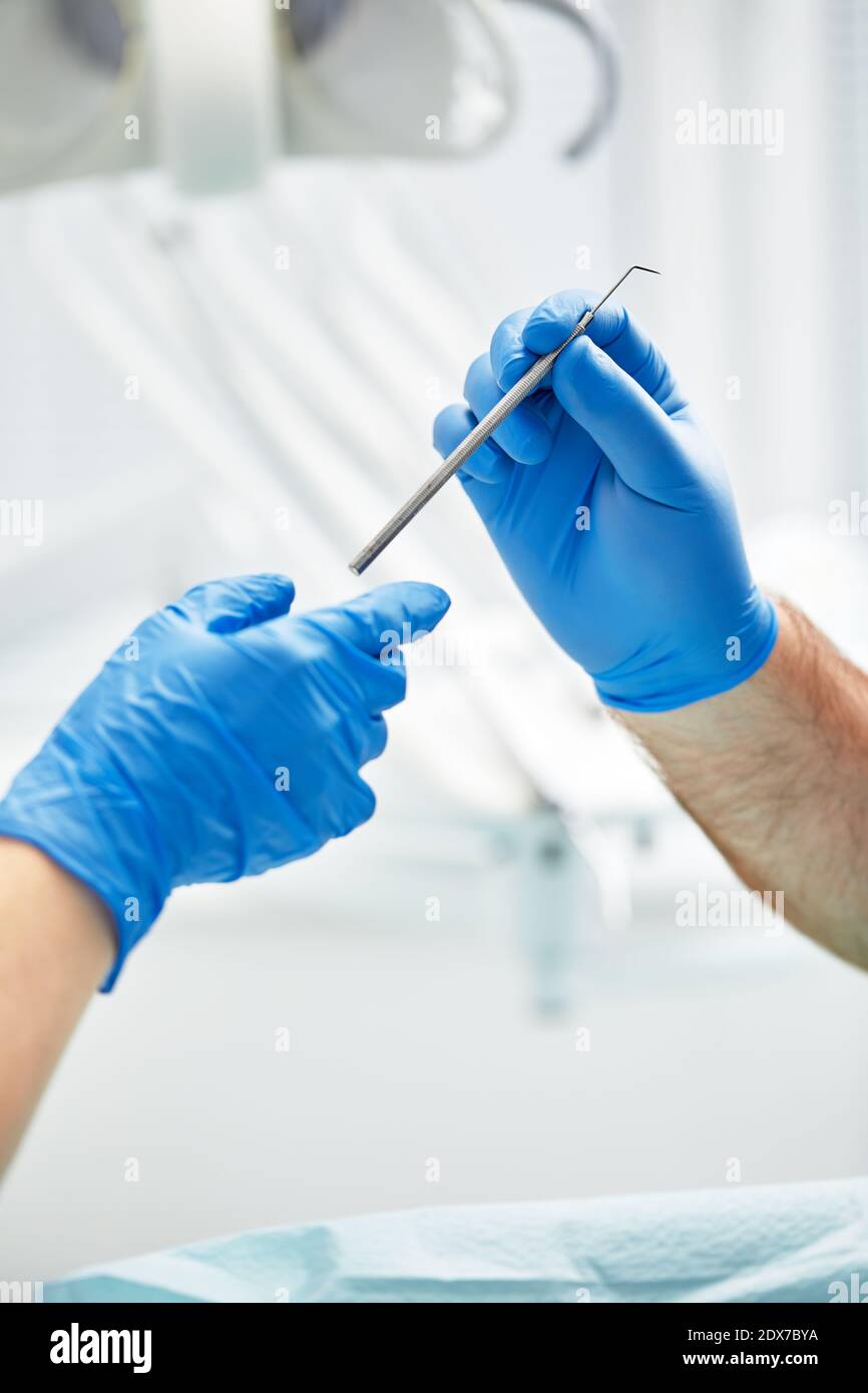 Close-up of the hands of a dentist and nurse surgeon over an operating ...