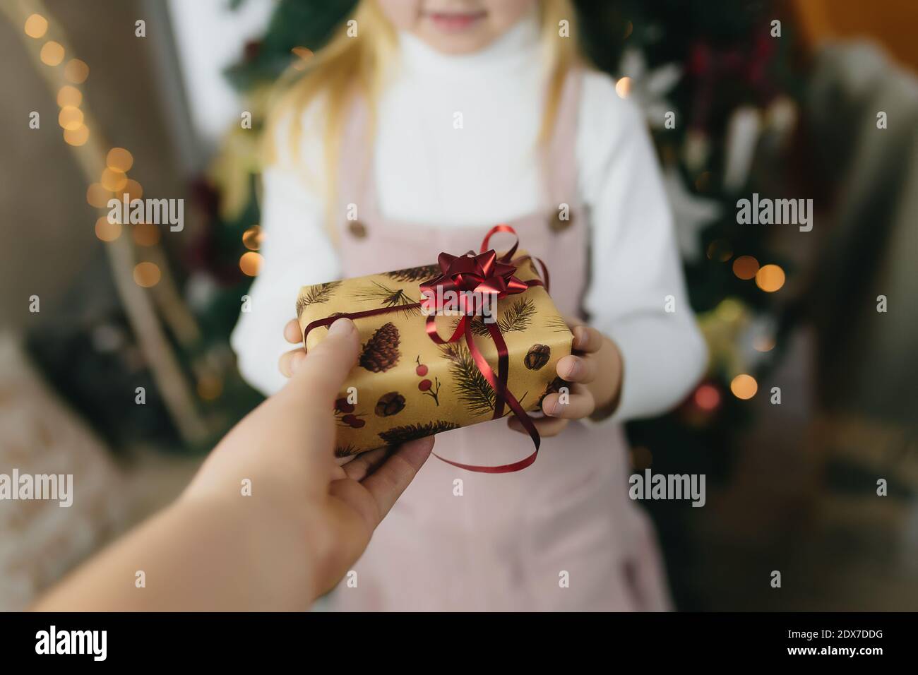 Christmas gift in hands, giving gift at home, little girl receiving a ...