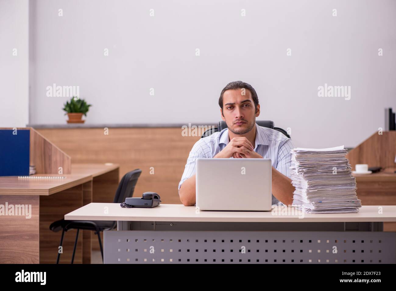 Young employee and many paperwork in the office Stock Photo - Alamy