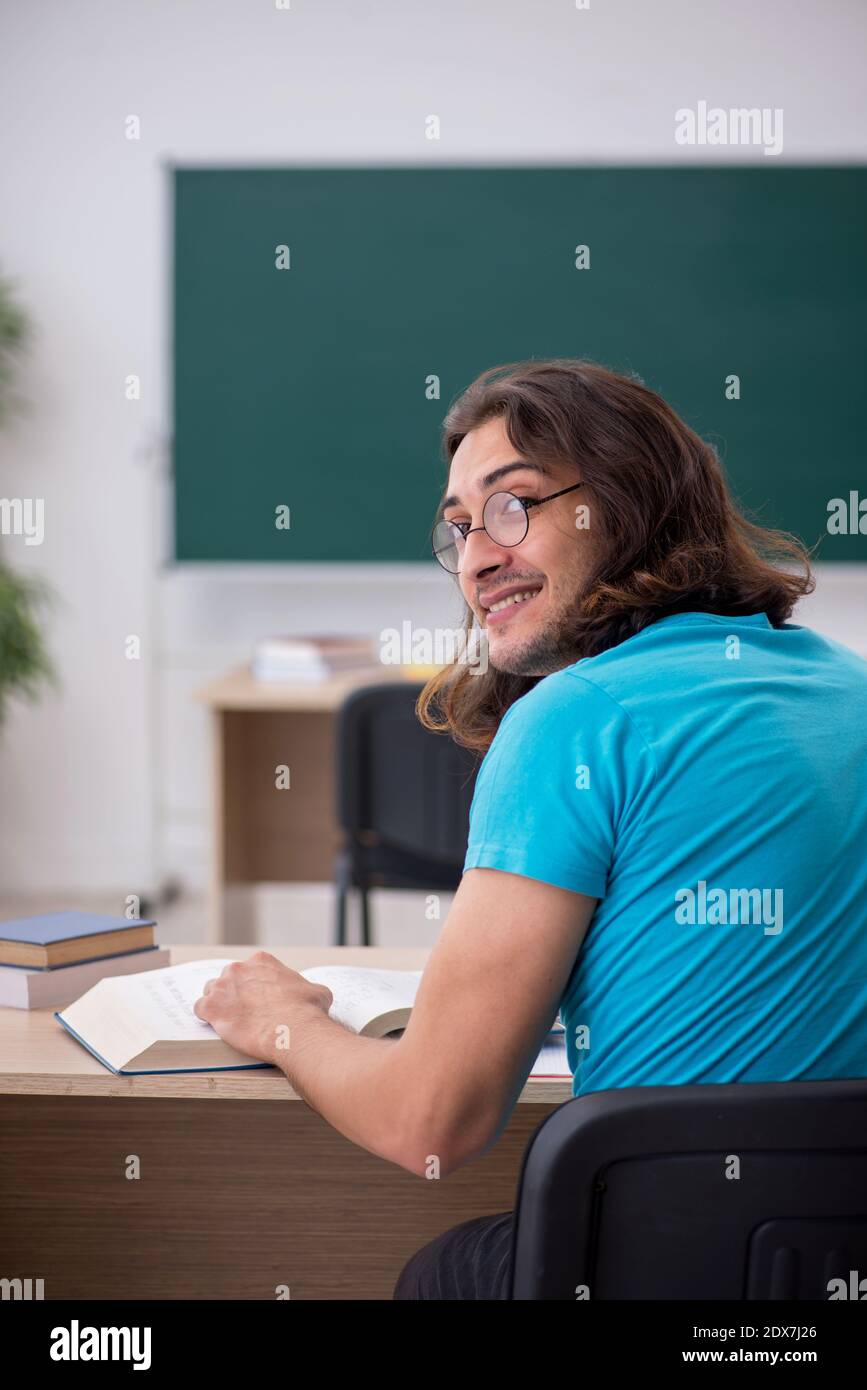 Young student in front of green board Stock Photo - Alamy