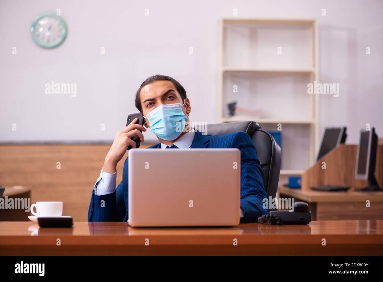 Young employee working in the office wearing mask Stock Photo - Alamy