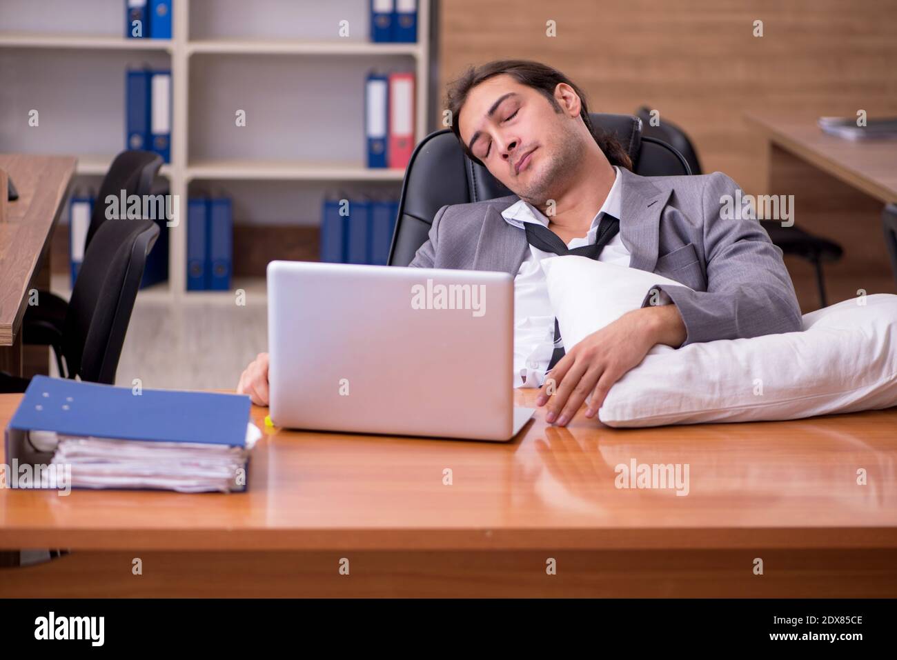 Young employee sleeping at workplace Stock Photo - Alamy
