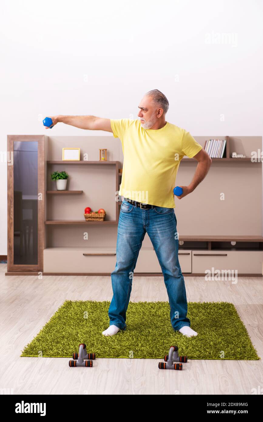 Old man doing sport exercises at home Stock Photo - Alamy