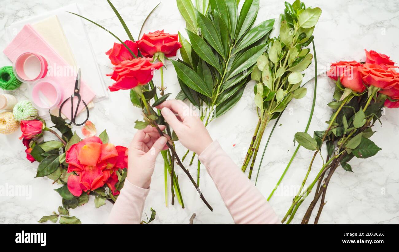 Flat lay. Florist running red roses for bouquet arrangement Stock Photo ...