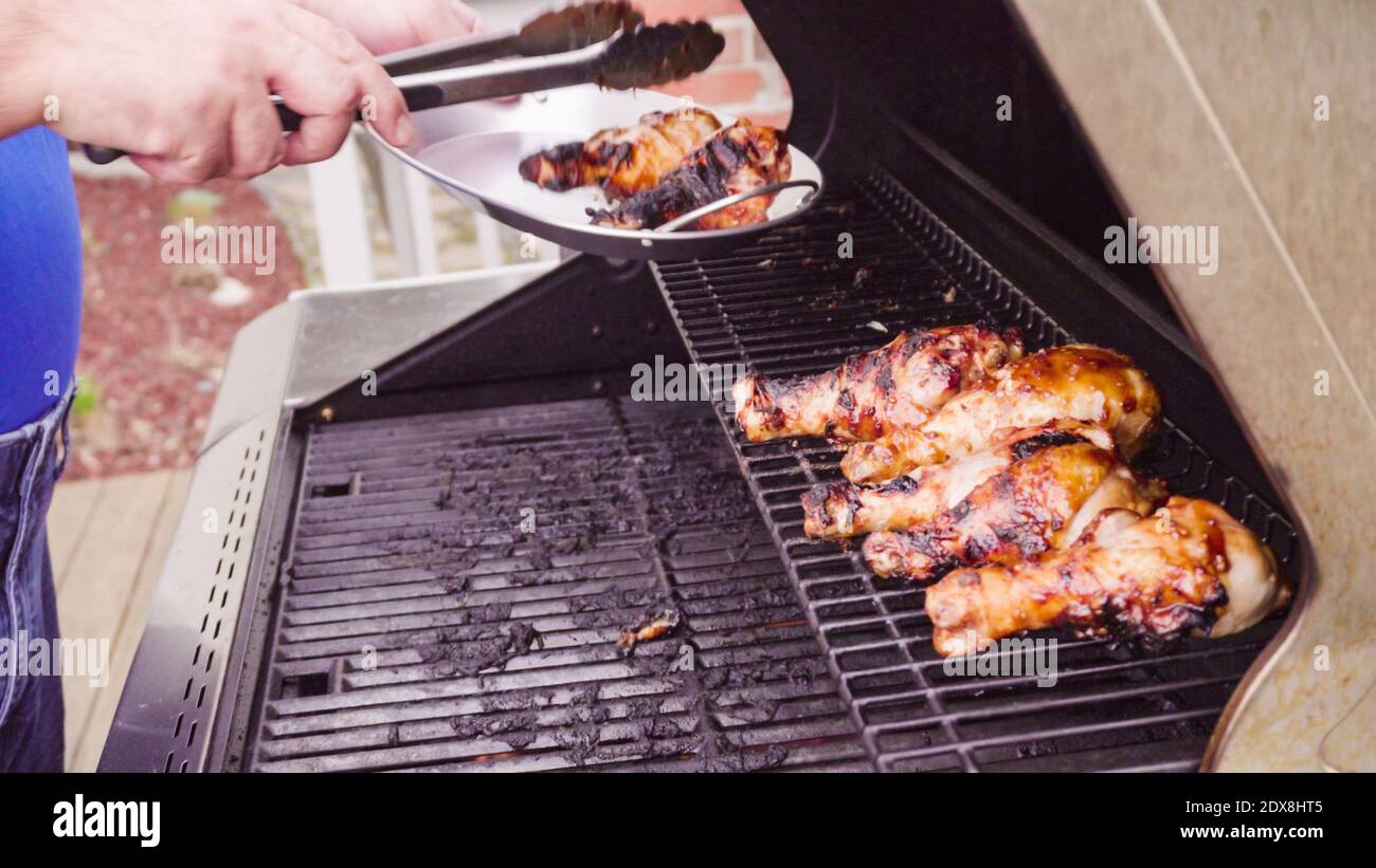Grilling BBQ chicken on outdoor gas grill Stock Photo - Alamy