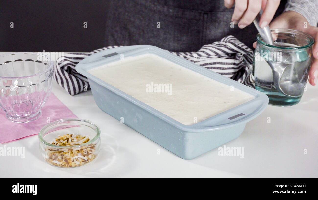 Scooping homemade coconut ice cream into a glass ice cream bowl Stock ...
