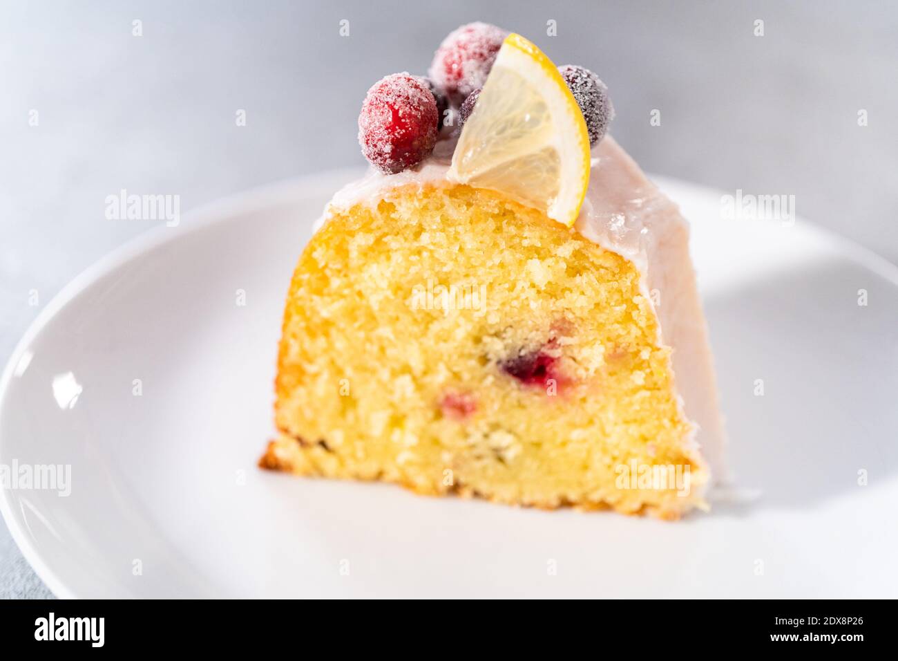 Slice the lemon cranberry bundt cake on a white plate Stock Photo - Alamy