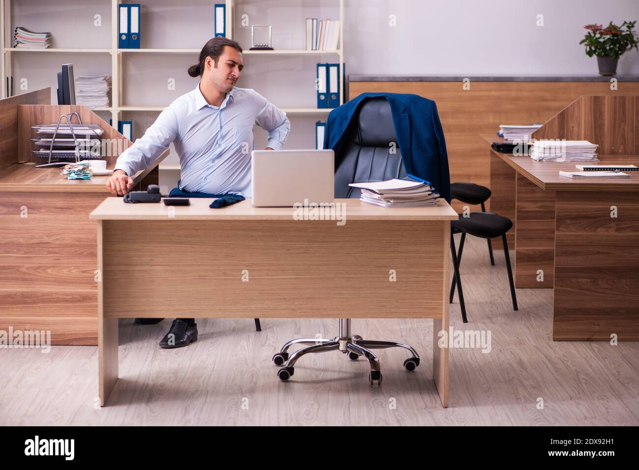 Young employee stretching at workplace Stock Photo - Alamy