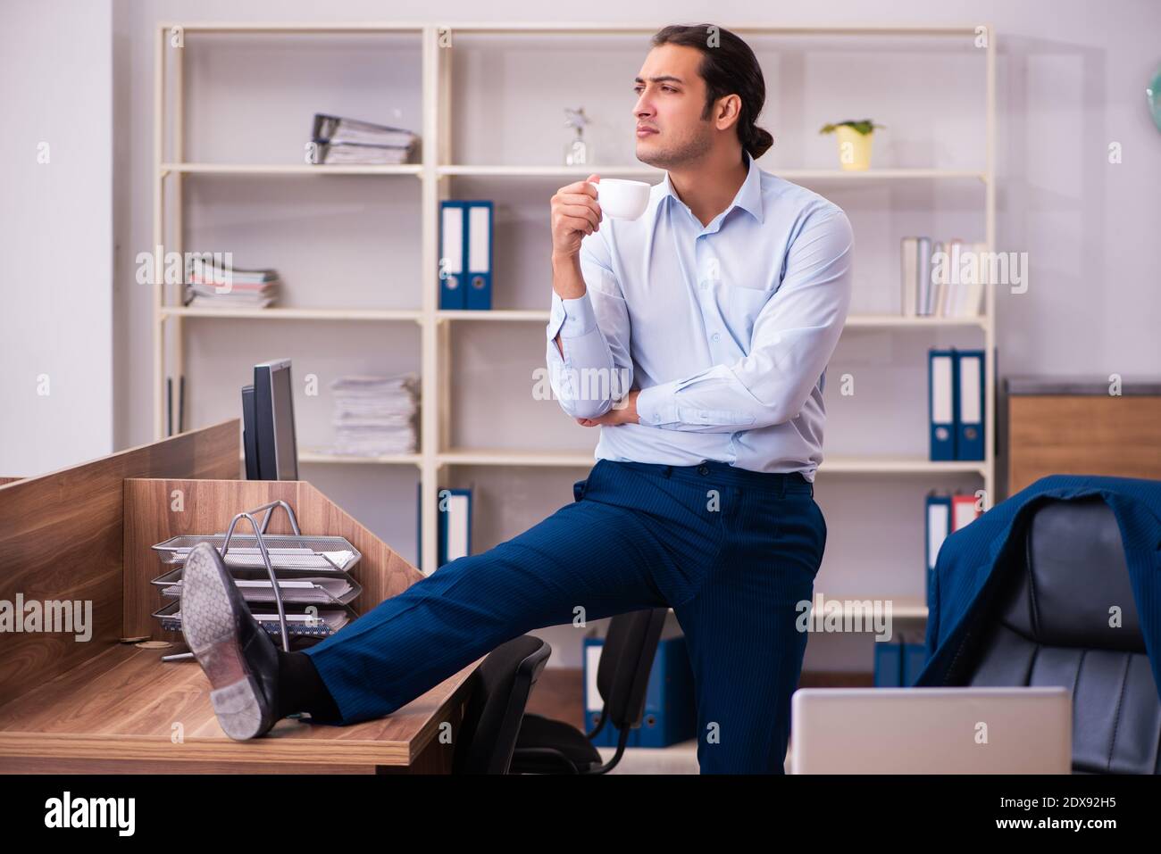 Young employee doing physical exercises at workplace Stock Photo - Alamy