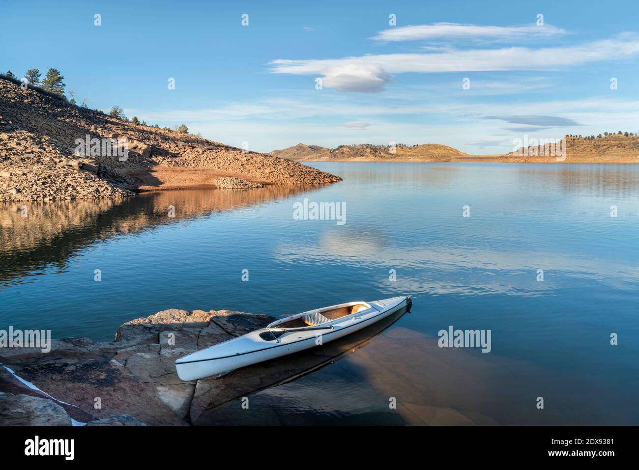 decked expedition canoe on a rocky shore of a mountain lake ...